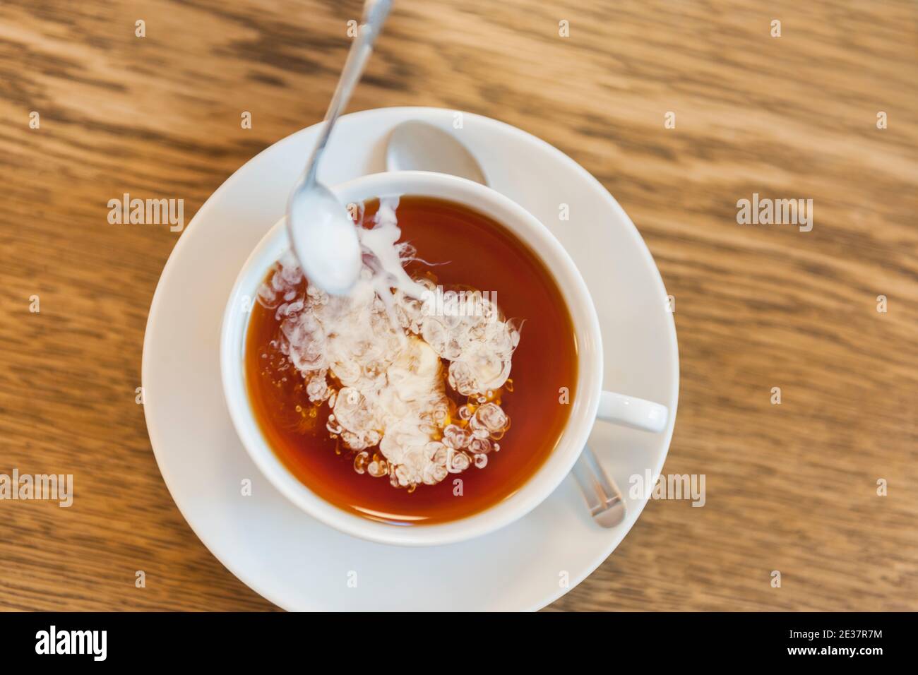 Top View Closeup of a white cup of tea with freshly poured cream ...