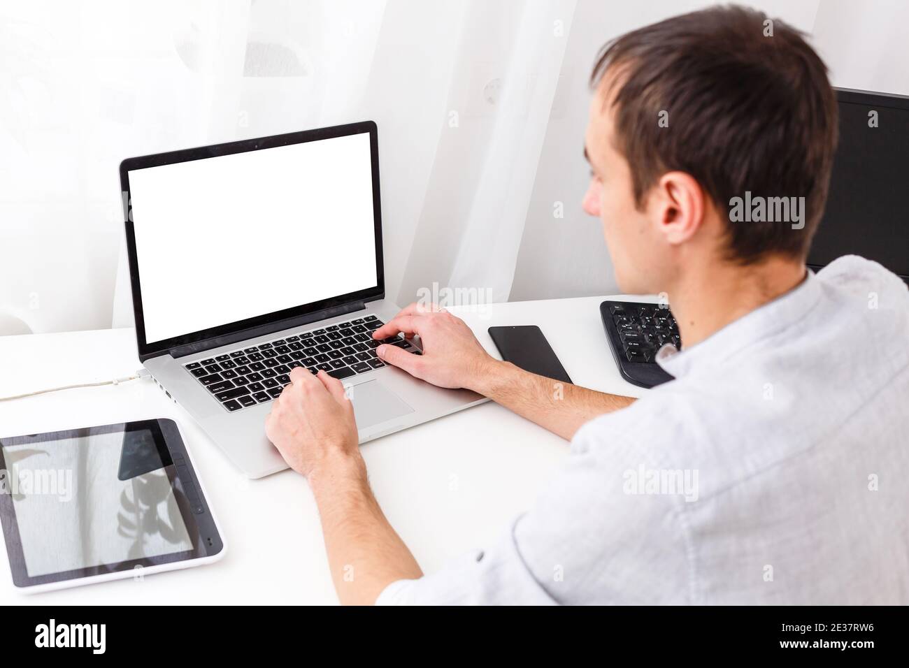 Back view of male person sitting front open laptop computer with blank ...