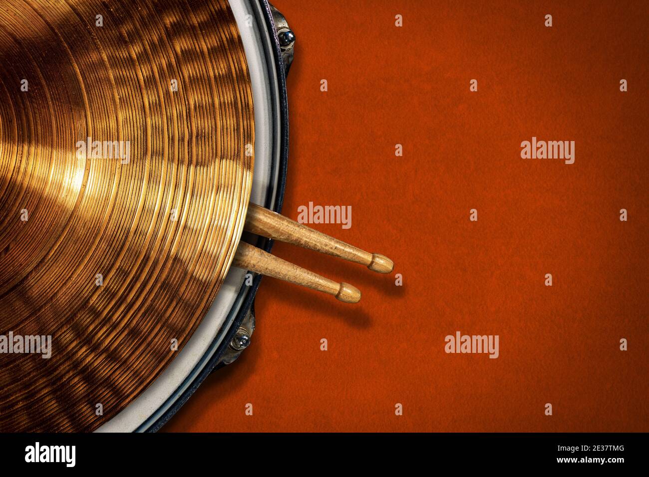 Closeup of a golden colored cymbal on a snare drum with two wooden ...