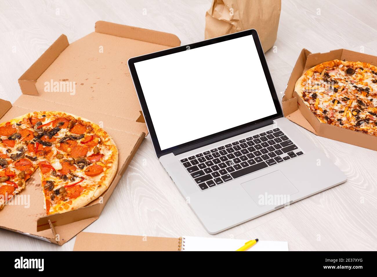 Laptop with blank white screen in kitchen. Culinary courses or recipe ...