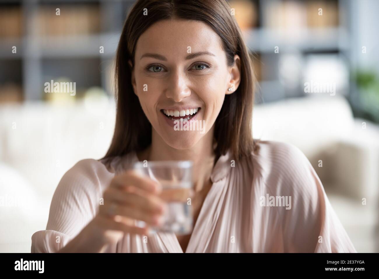 Head shot portrait smiling woman offering glass of water Stock Photo ...