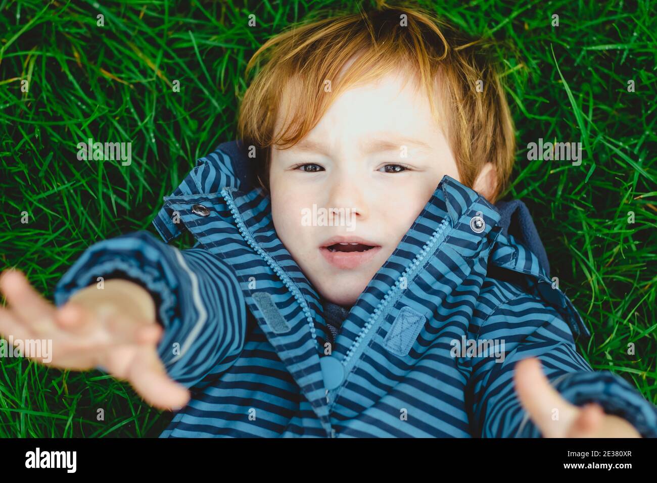 Boy lying on grass arms hi-res stock photography and images - Alamy