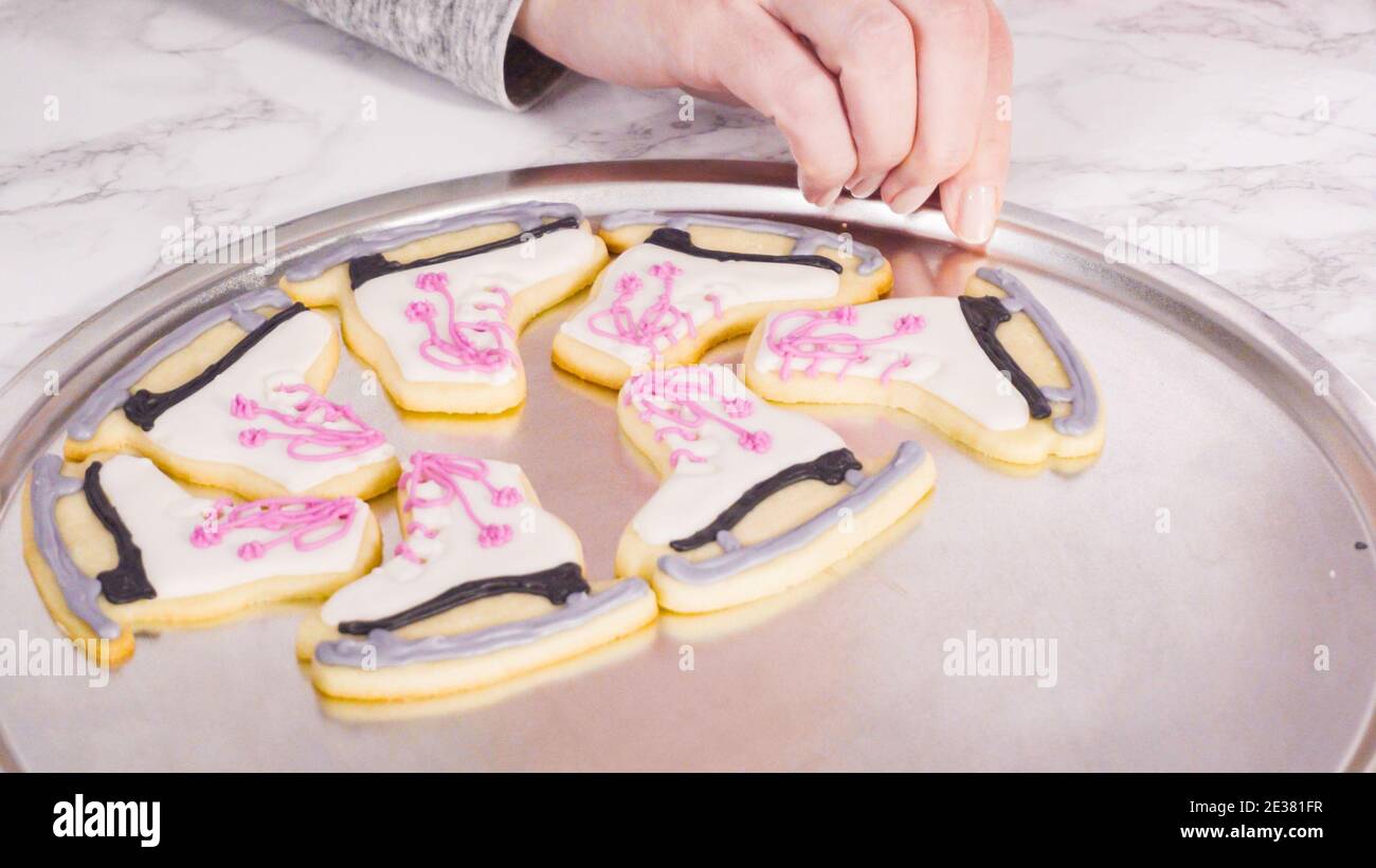 Brushing edible glitter on iced figure skate sugar cookies Stock Photo ...
