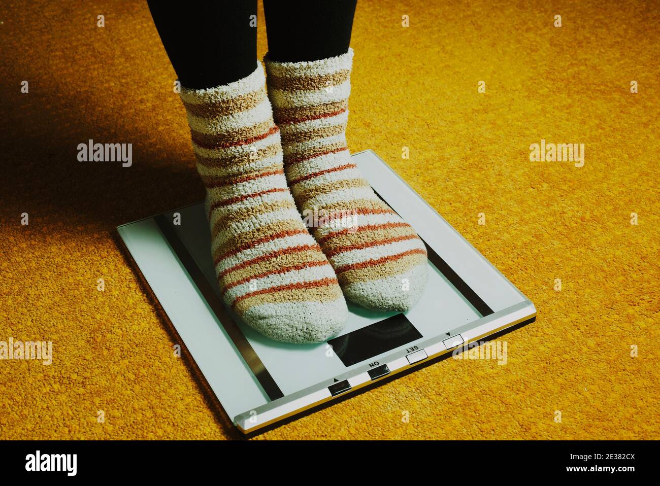 woman feet with socks and scales on yellow carpet Stock Photo - Alamy