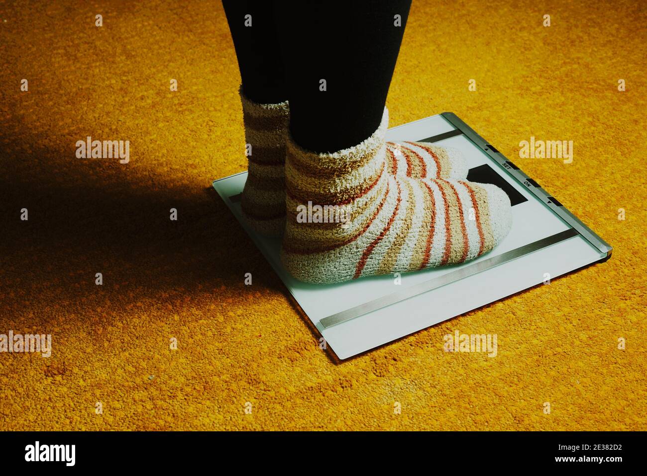 woman feet with socks and scales on yellow carpet Stock Photo - Alamy