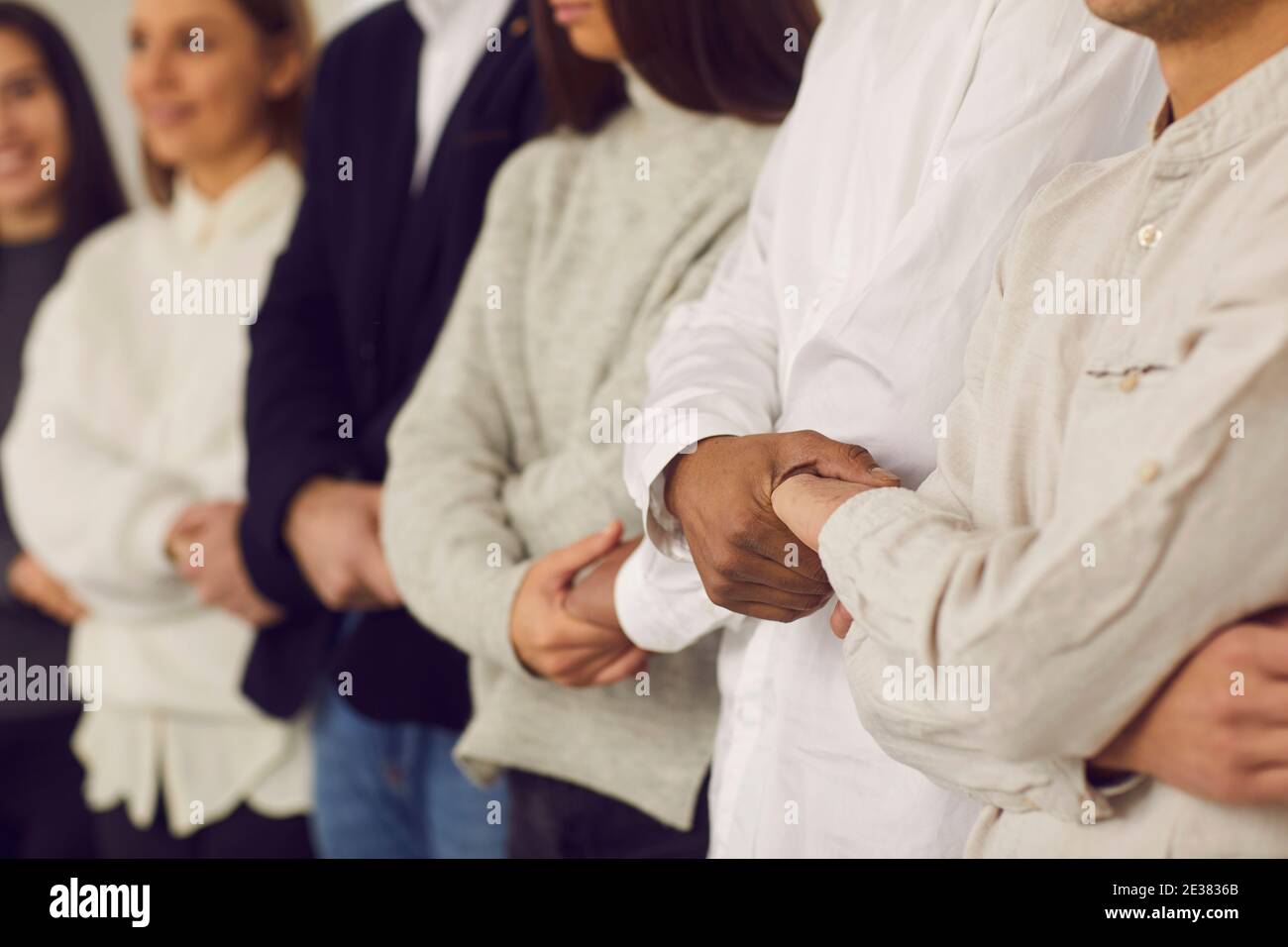 Group of business men and women holding hands, feeling united and ...