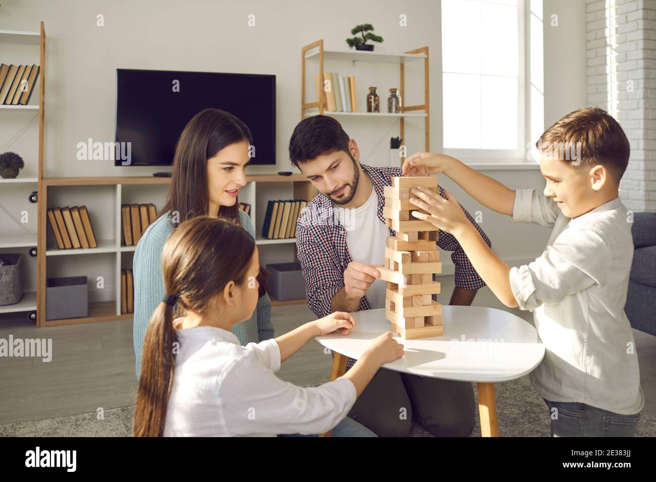 Concentrated parents and children playing jenga while enjoying free ...