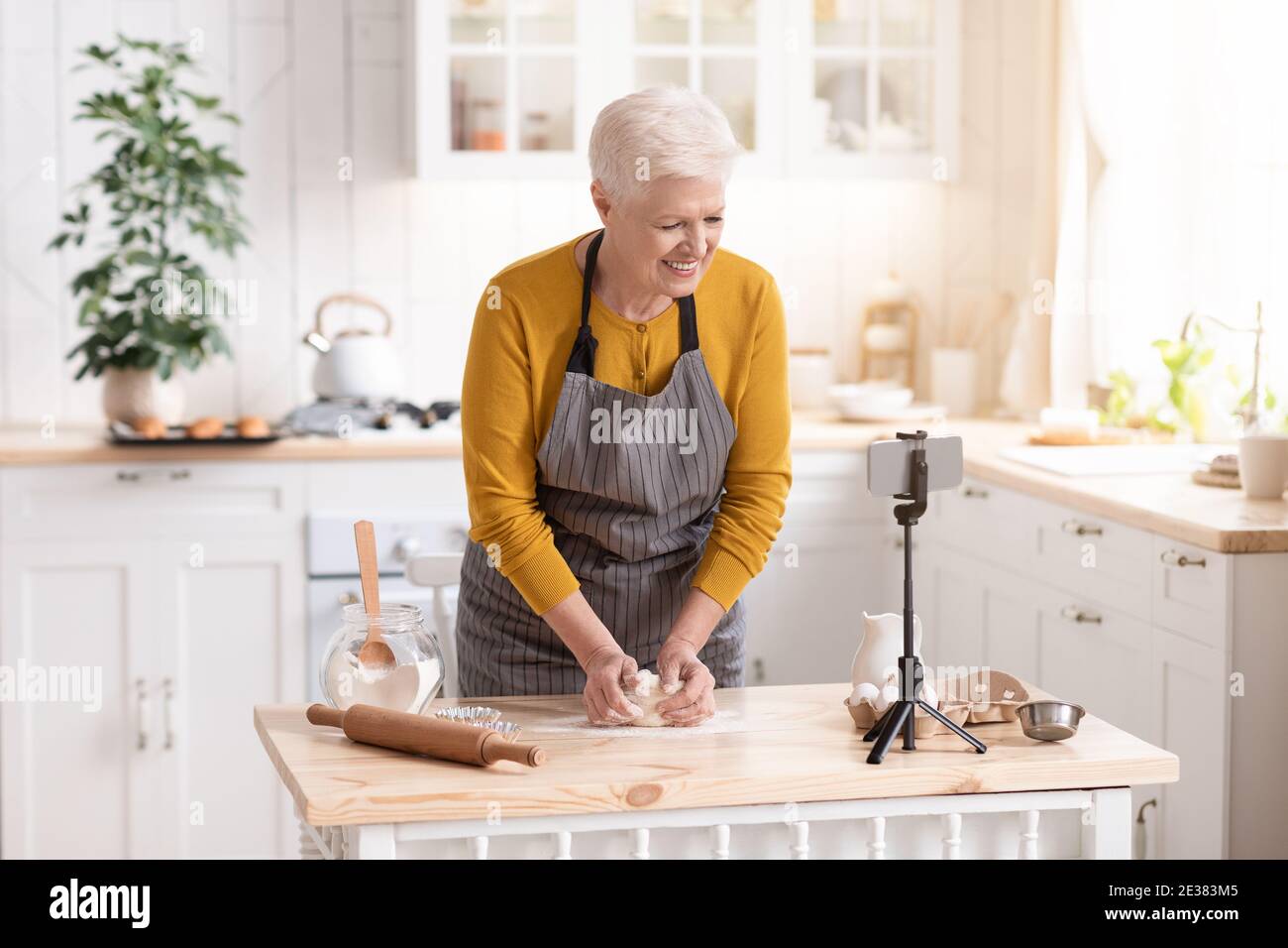 Old lady food blogger making dough in front of camera Stock Photo - Alamy
