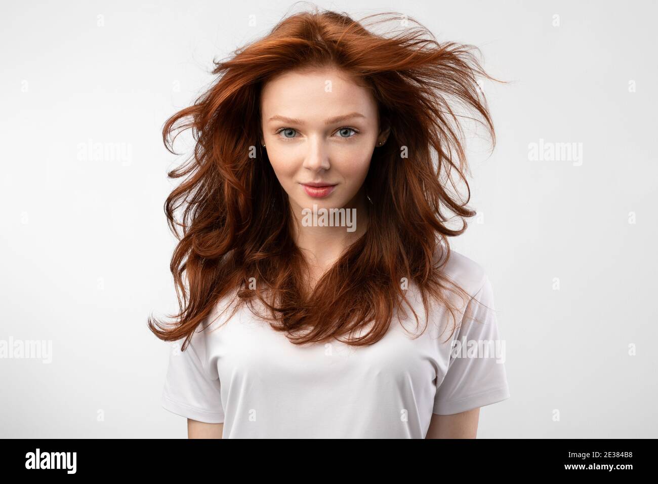 Red-Haired Young Woman With Loose Hair Posing Over White Background ...