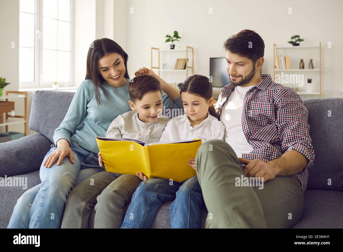 Happy family with kids reading an interesting book while enjoying ...