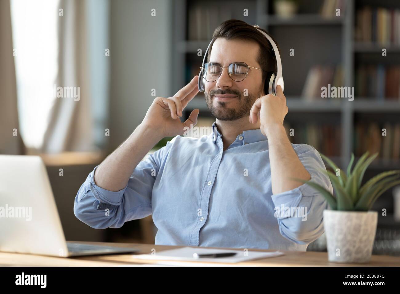 Relaxed young happy businessman listening music in headphones Stock ...