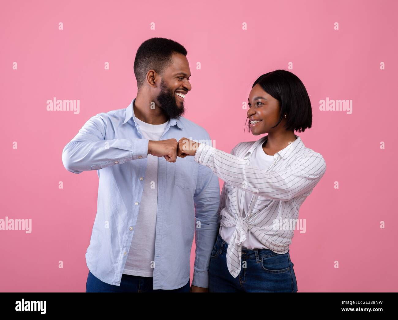 Cooperation, teamwork, partnership. Black couple making fist bump and ...