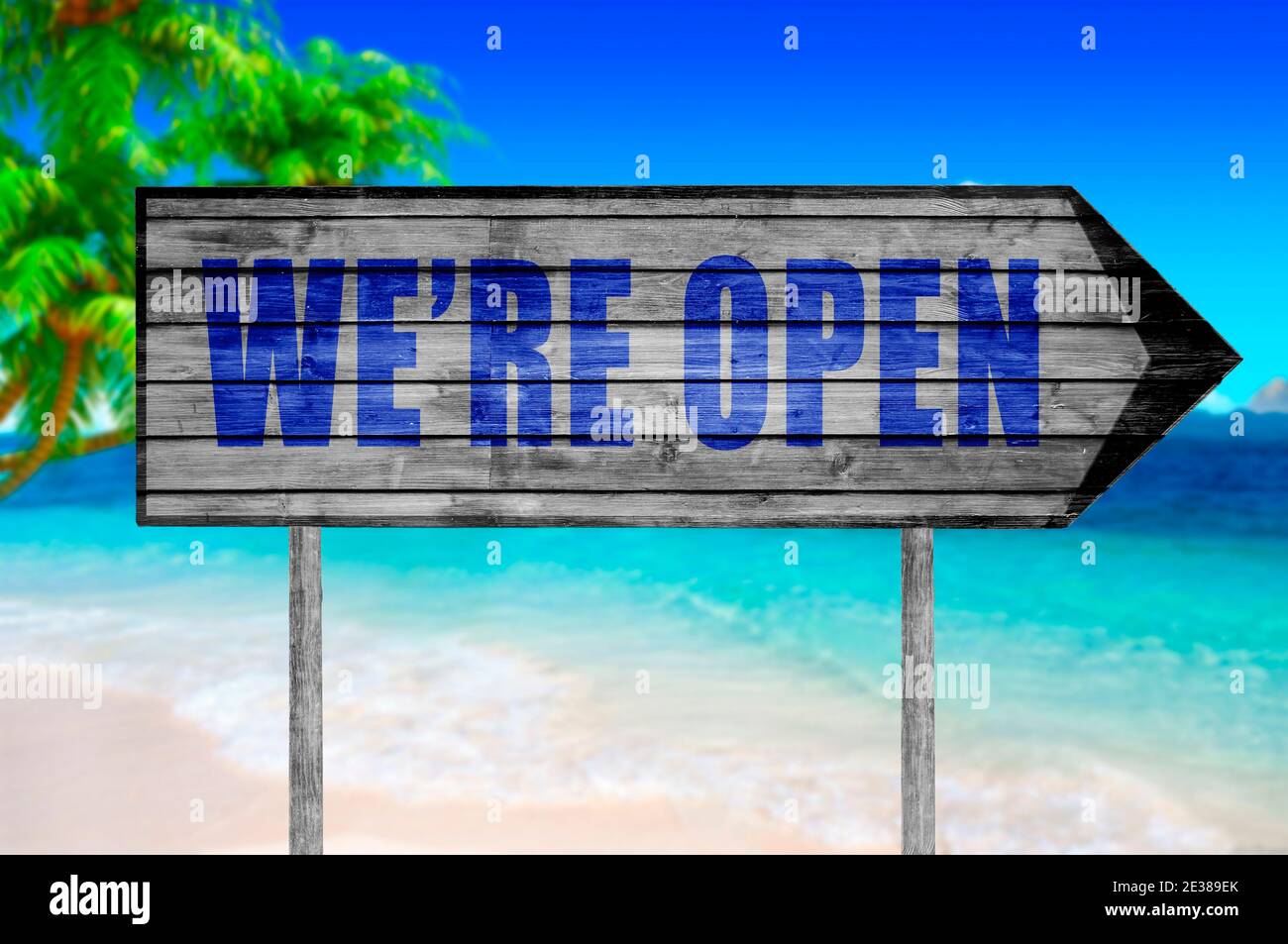 We're open wooden sign with on a beach background Stock Photo - Alamy