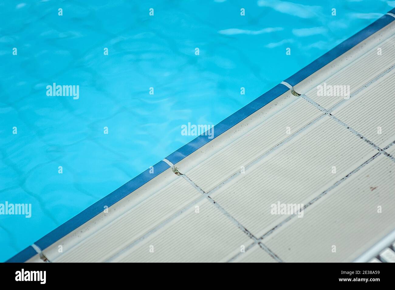 Swimming pool with clear blue water and white tiles. triangle form ...