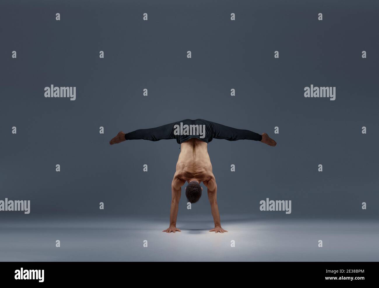 Male yoga does split on hands, back view Stock Photo - Alamy