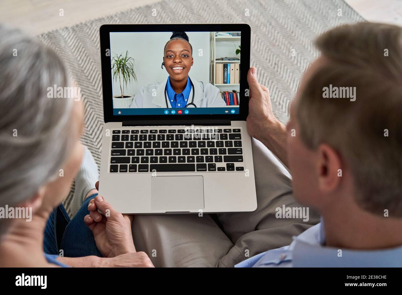 Over shoulder view of old couple patient video calling virtual doctor ...