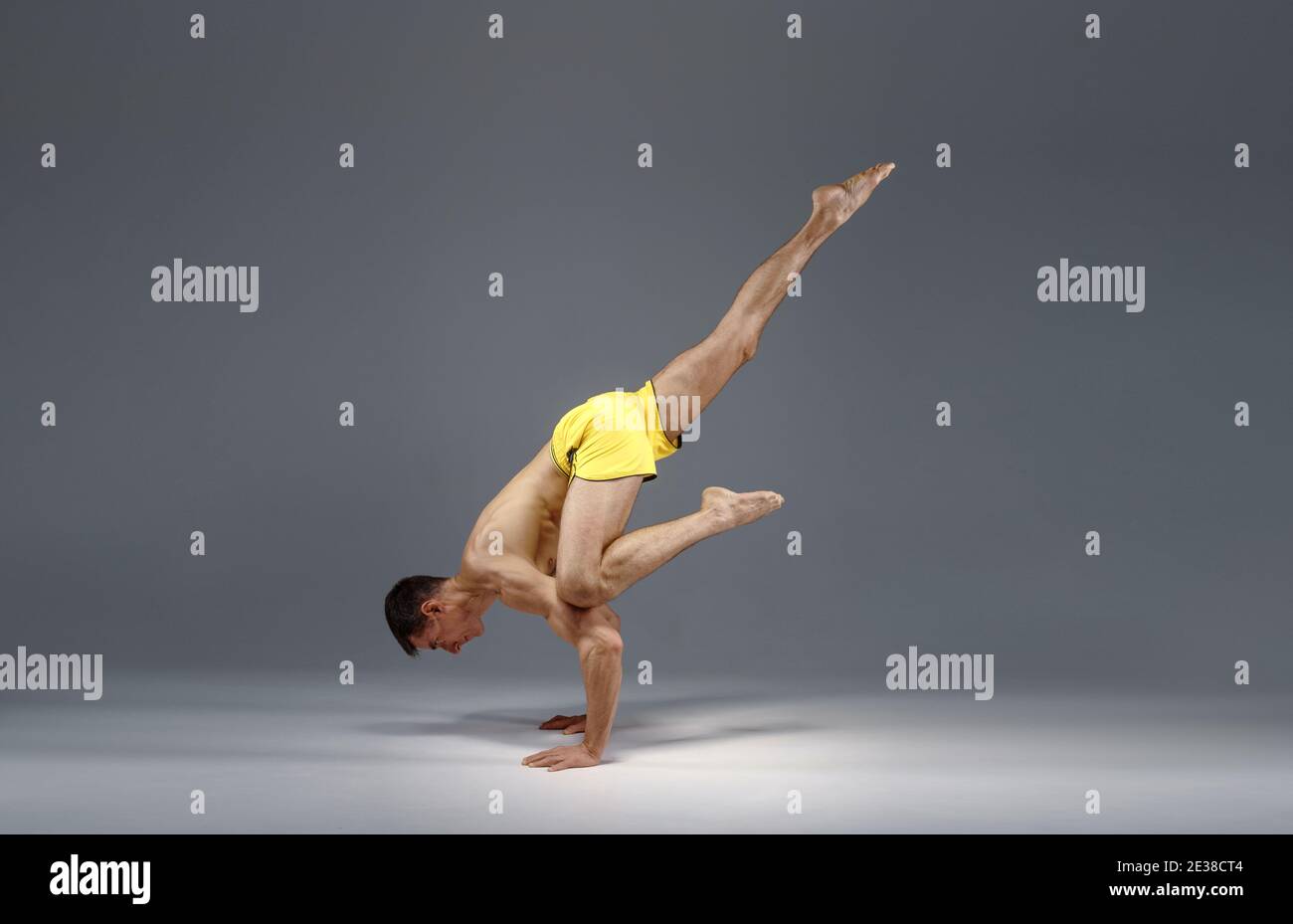 Muscular yoga stands on hands in difficult pose Stock Photo - Alamy