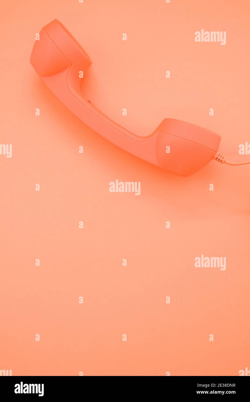 A vertical shot of a classic handset on pastel orange background for a ...