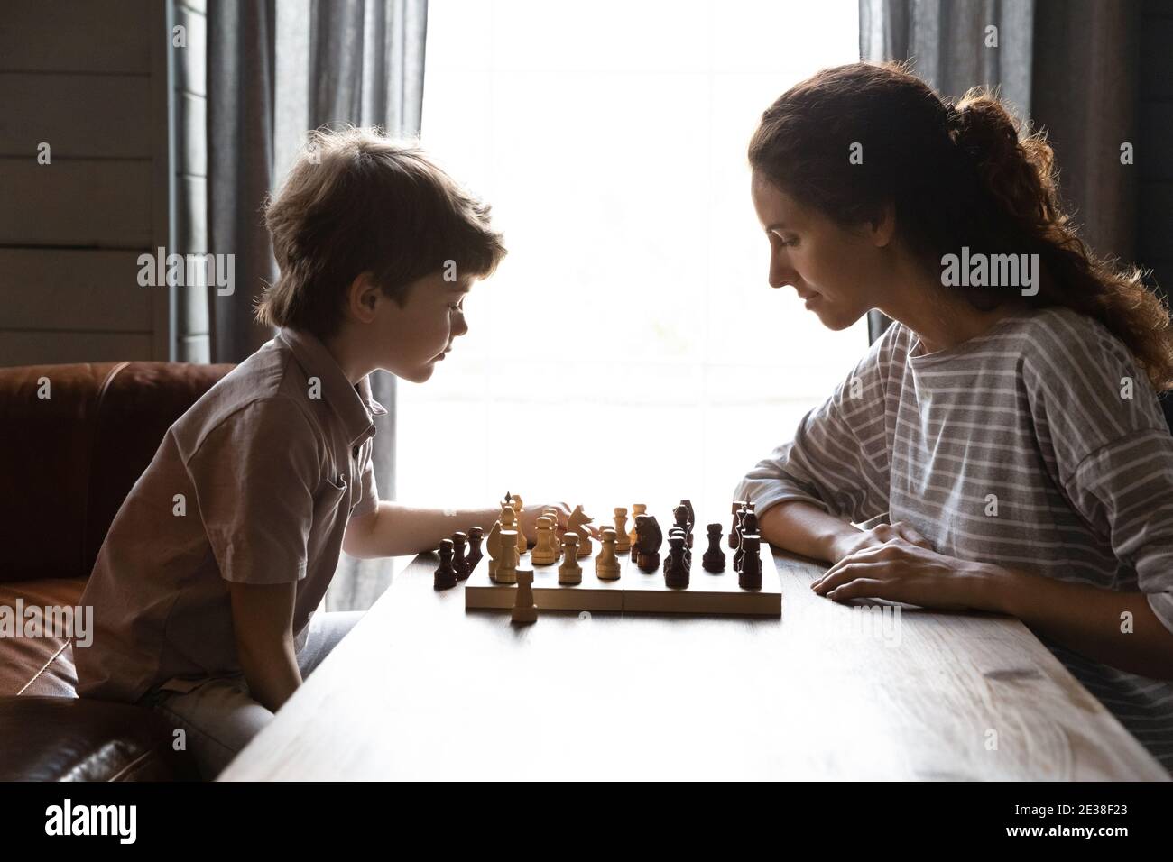 Mother play chess with smart little son Stock Photo - Alamy