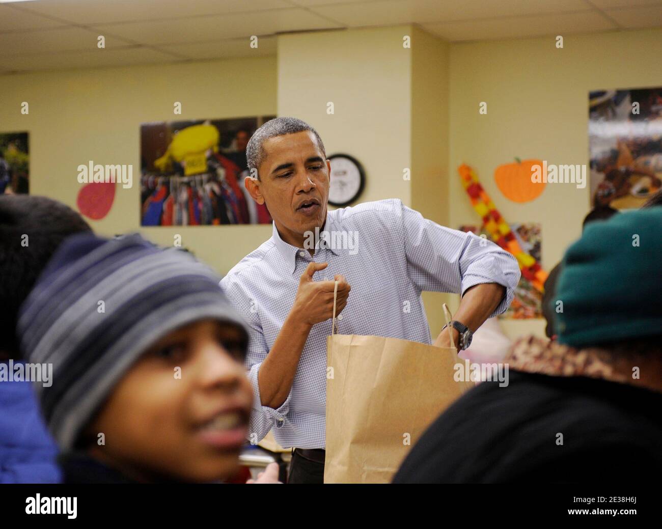 US President Barack Obama packs and gives bags of food to area ...