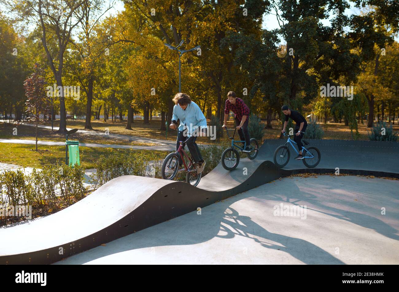 Three bmx riders on bikes, training in skatepark Stock Photo - Alamy