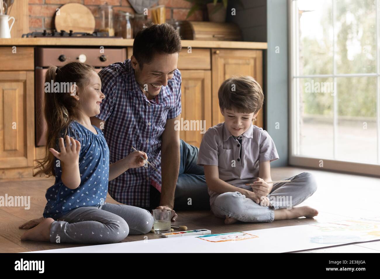 Caring dad drawing with two small kids at home Stock Photo - Alamy