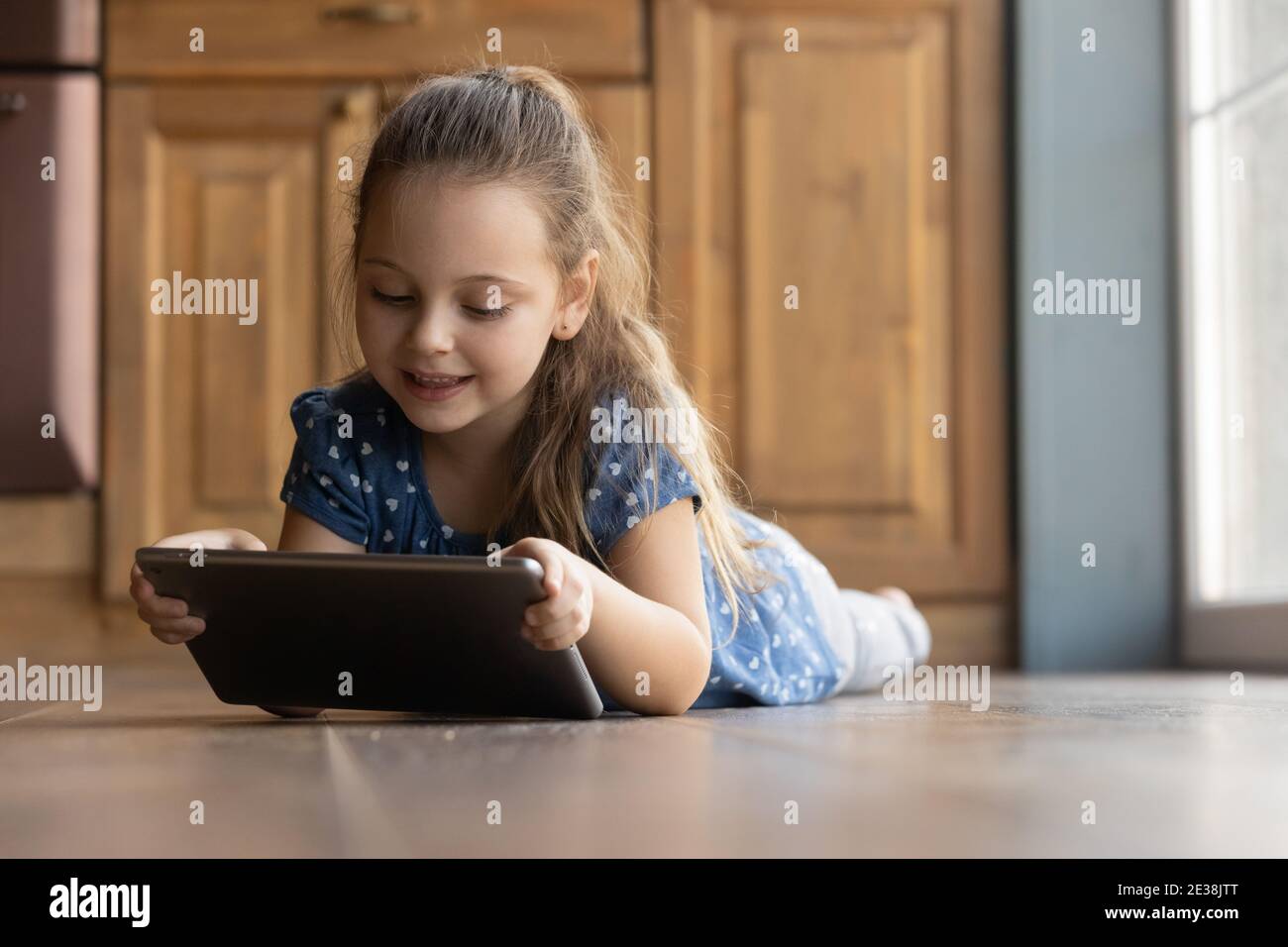 Happy little girl have fun using tablet gadget Stock Photo - Alamy