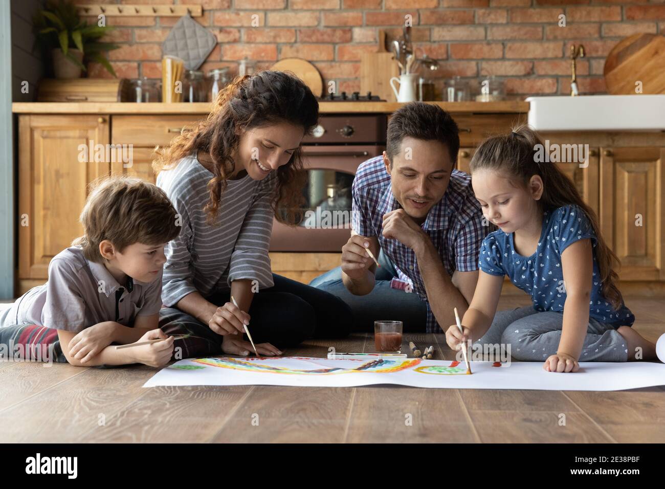 Happy parents with little kids drawing together Stock Photo - Alamy