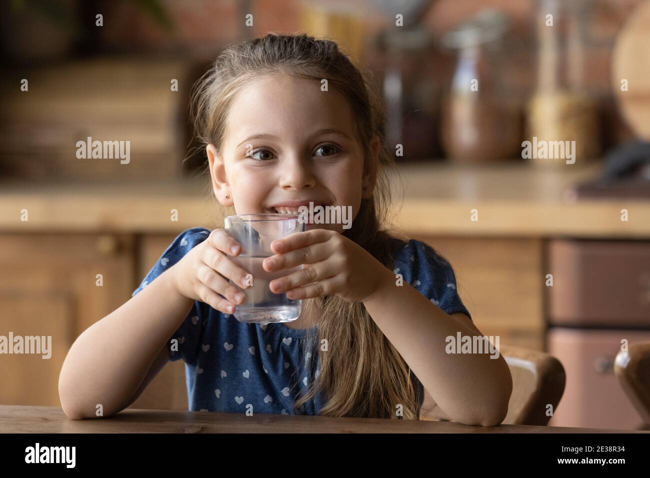 Happy little girl drink clean mineral water Stock Photo - Alamy