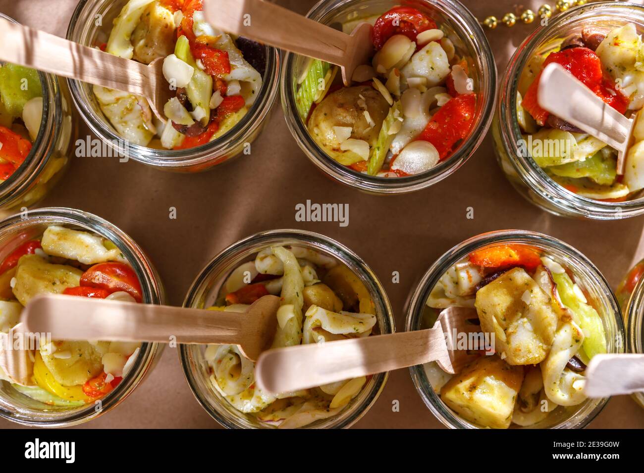 Cocktail of squid meat and seafood in glass jars with wooden forks. Eco ...