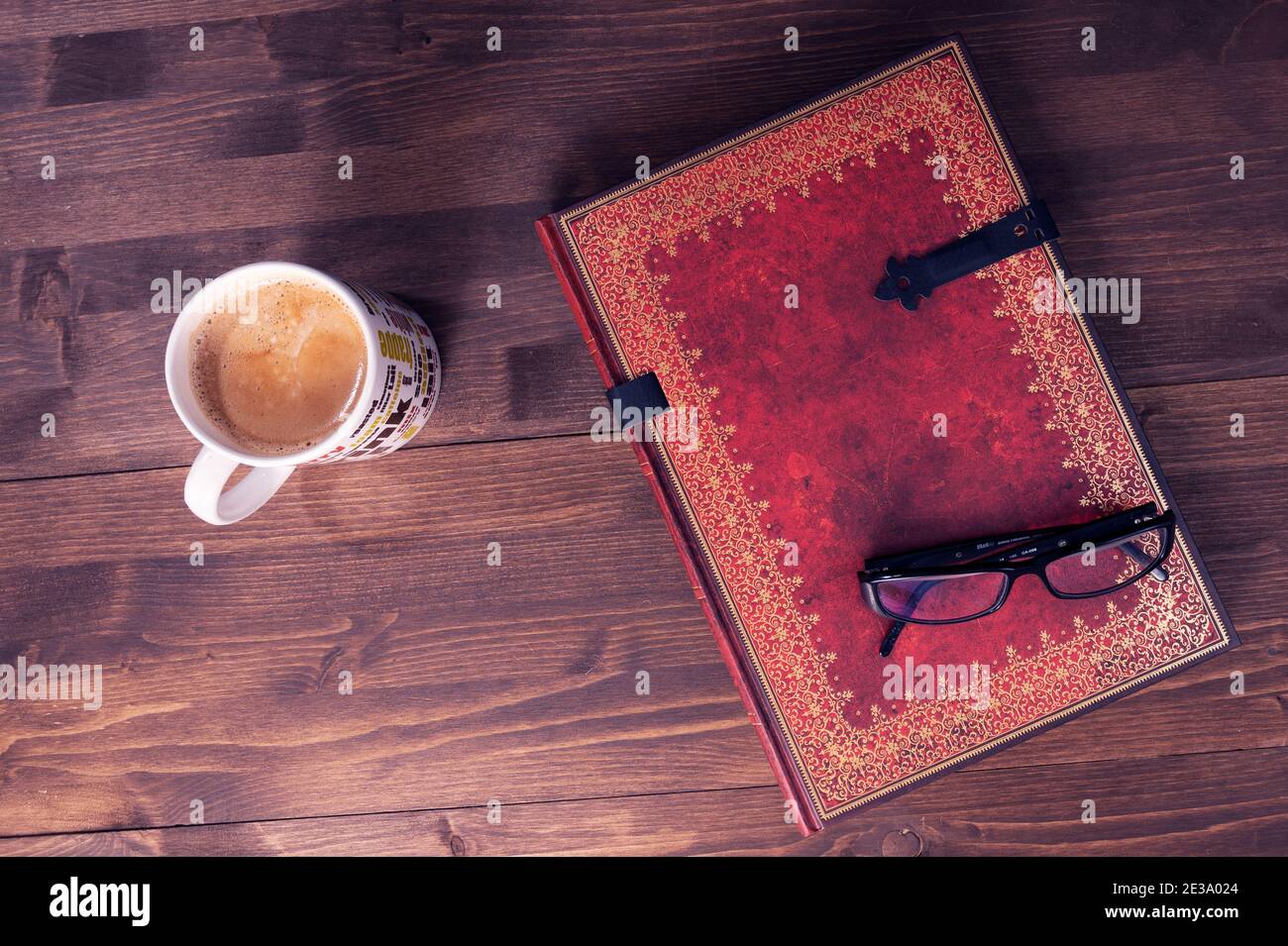 A high angle shot of a small notebook with a pen on a wooden table ...