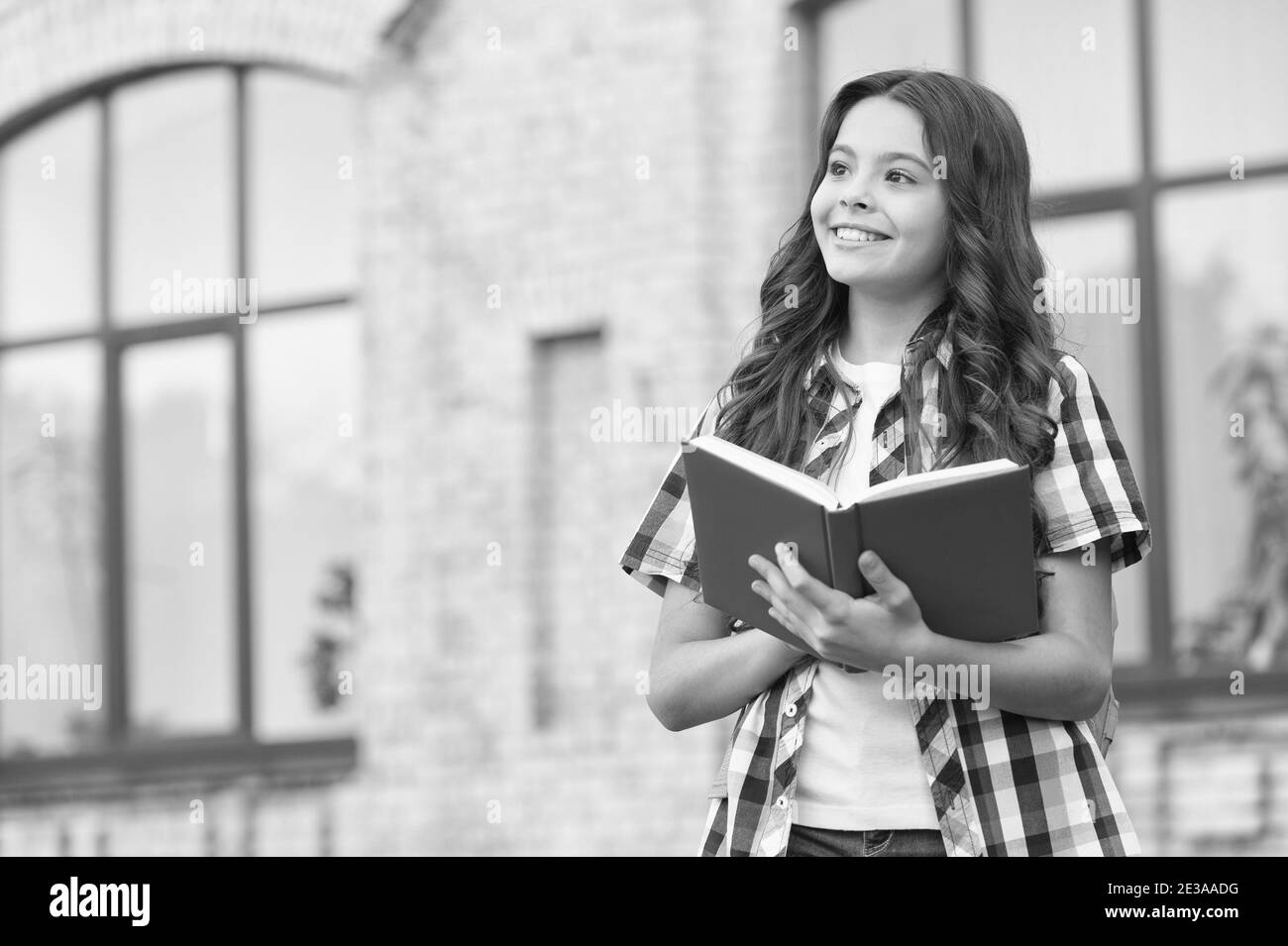 Imagine your dreams. Little kid hold book with thoughtful look ...