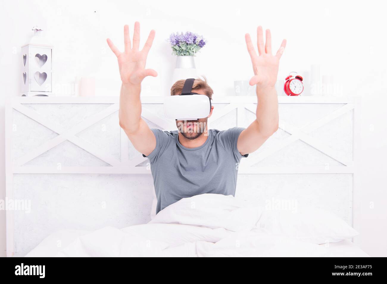 The best VR experience. Handsome guy wearing VR headset in bed ...
