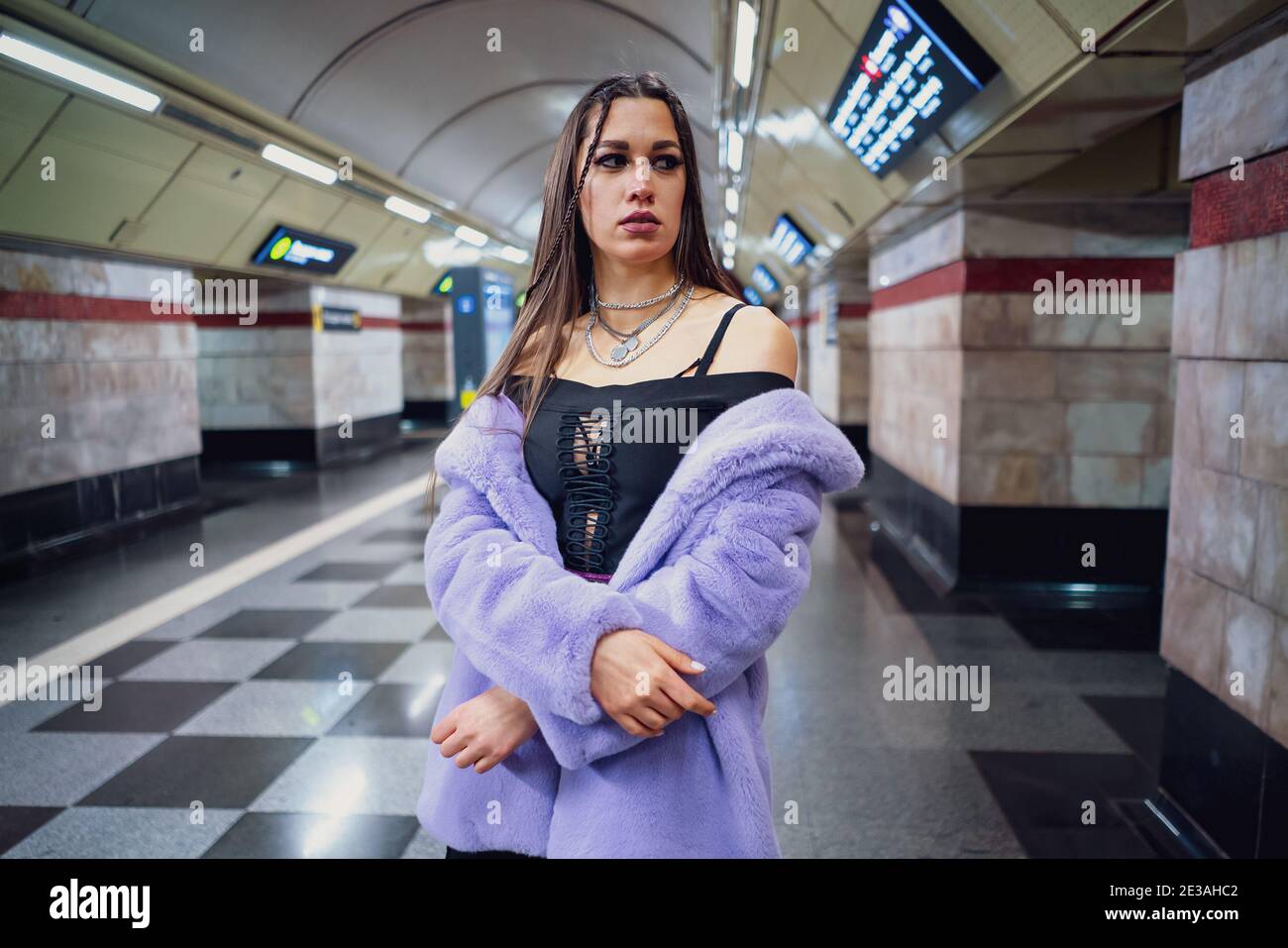 Fashion model girl in purple synthetic fur coat standing bared her ...