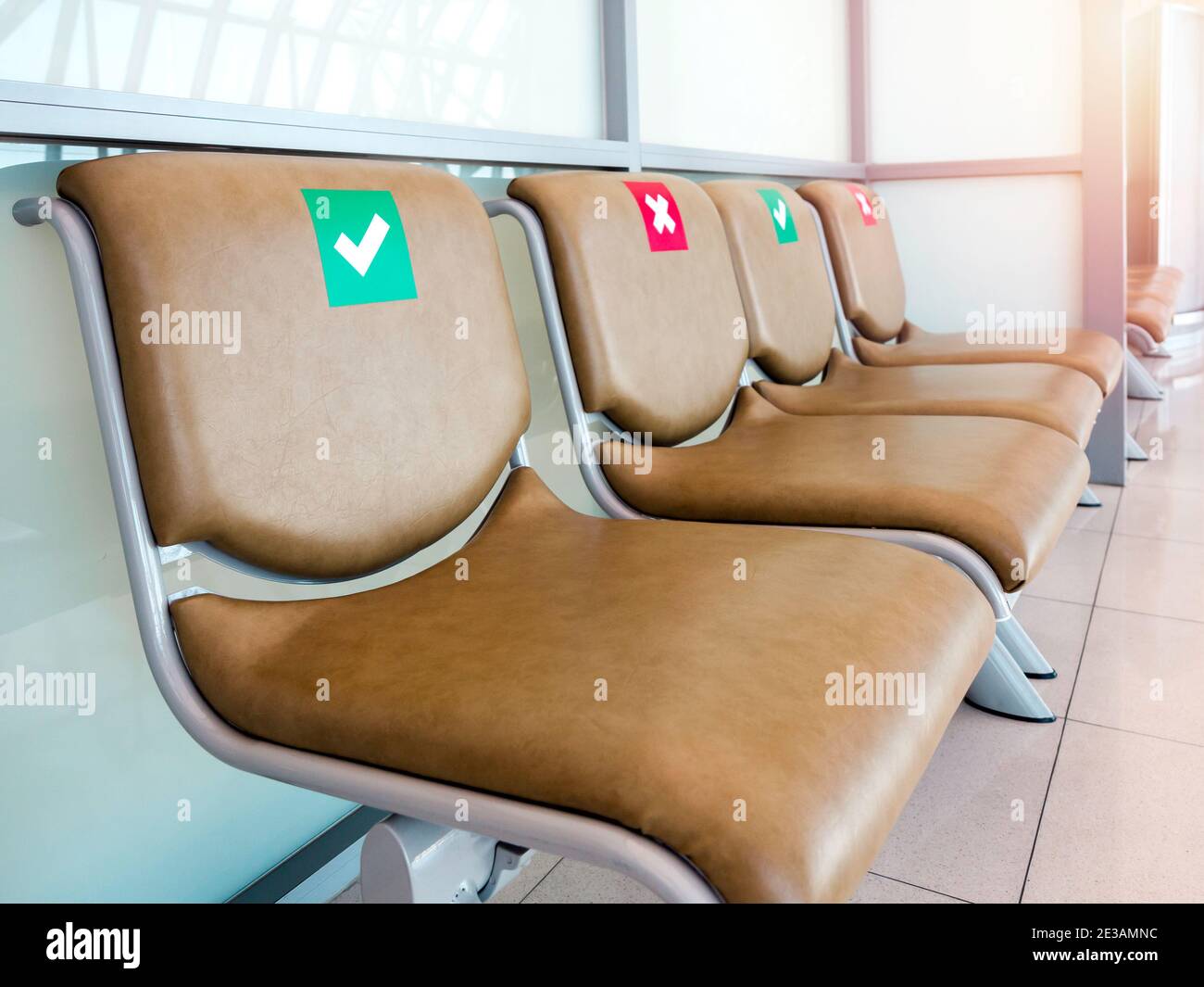 Close-up empty waiting chairs with social distancing sign, green check ...