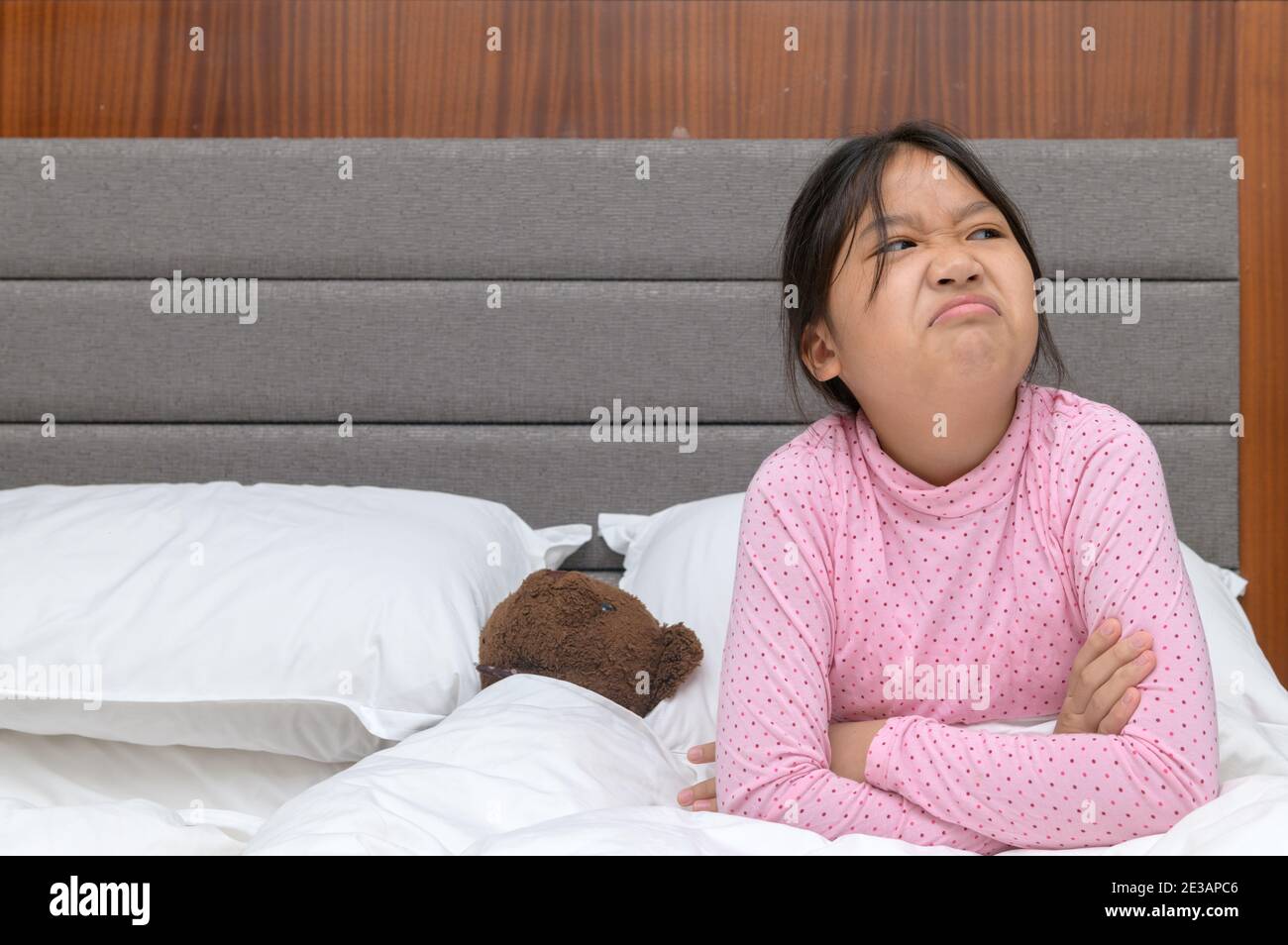 Angry girl sitting on bed and touchy in bedroom, upset and annoyed ...