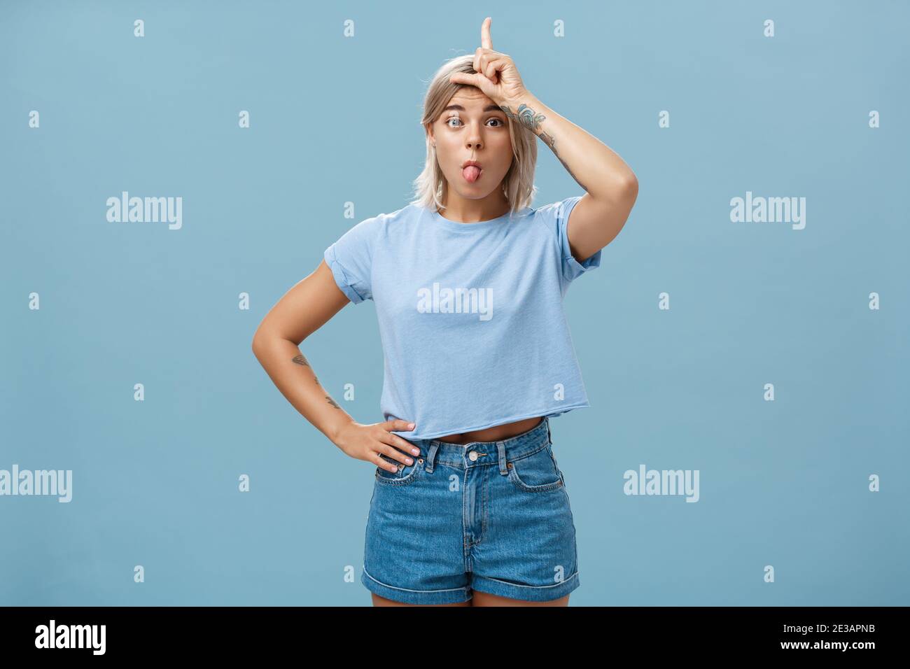 Studio shot of playful triumphing good-looking blonde female with ...