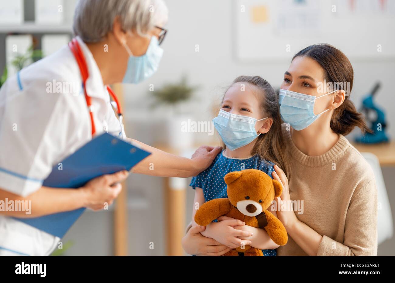 Doctor, child and mother wearing facemasks during coronavirus and flu ...