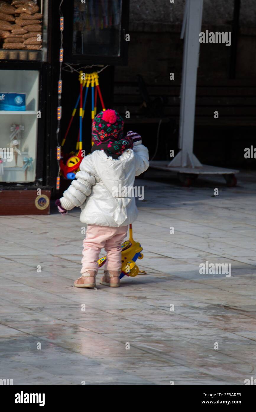 Back view of a little baby playing on the street Stock Photo - Alamy