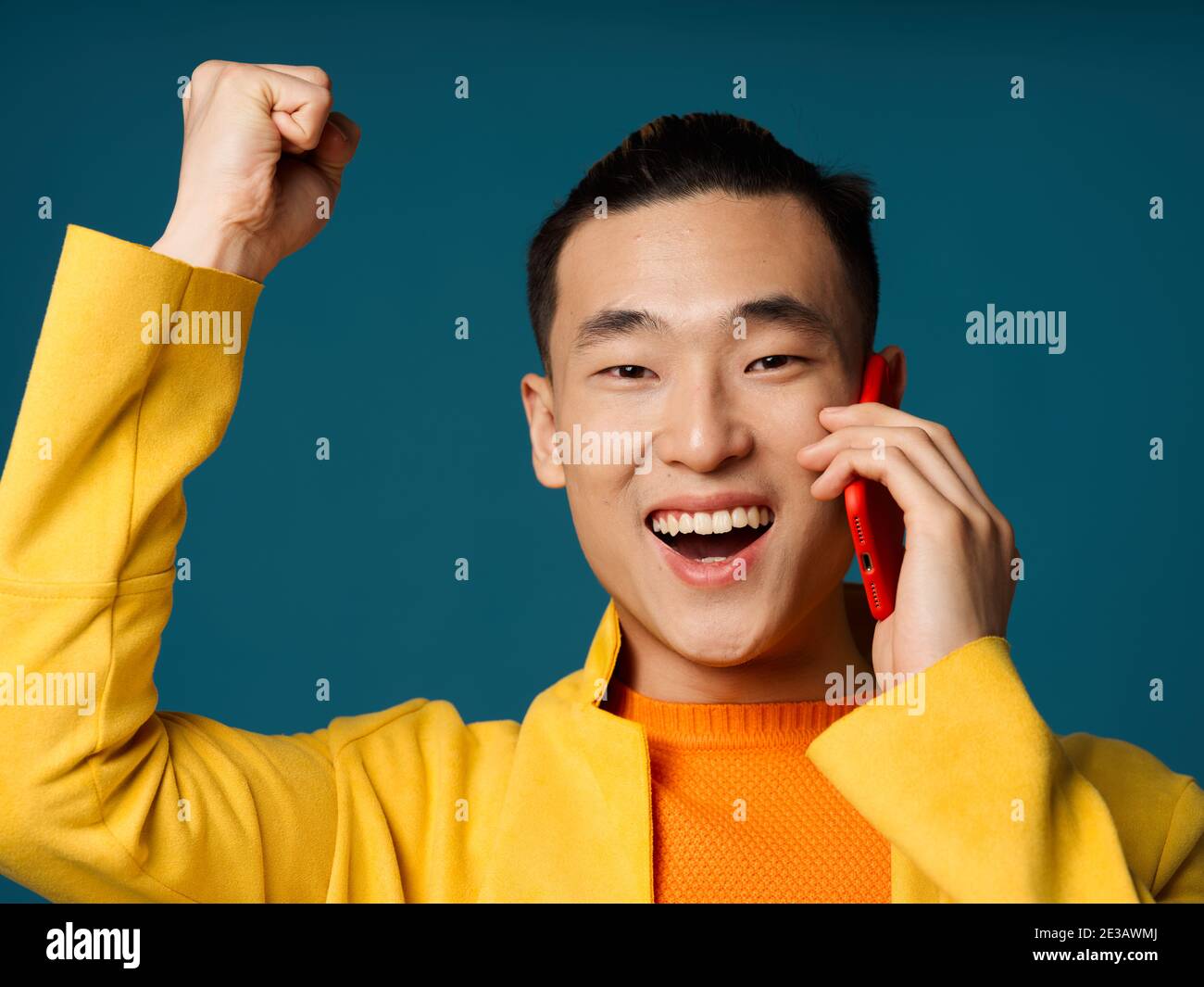 man with open mouth talking on the phone on a blue background joy ...