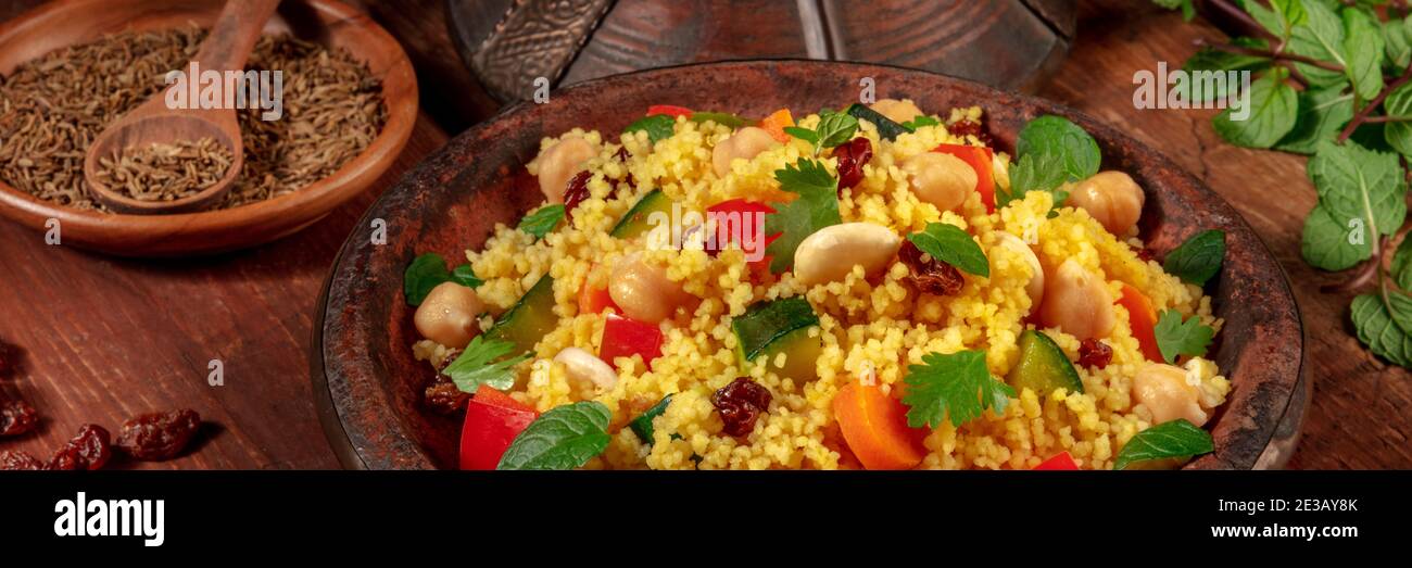 Couscous panorama with ingredients on a dark rustic wooden background ...