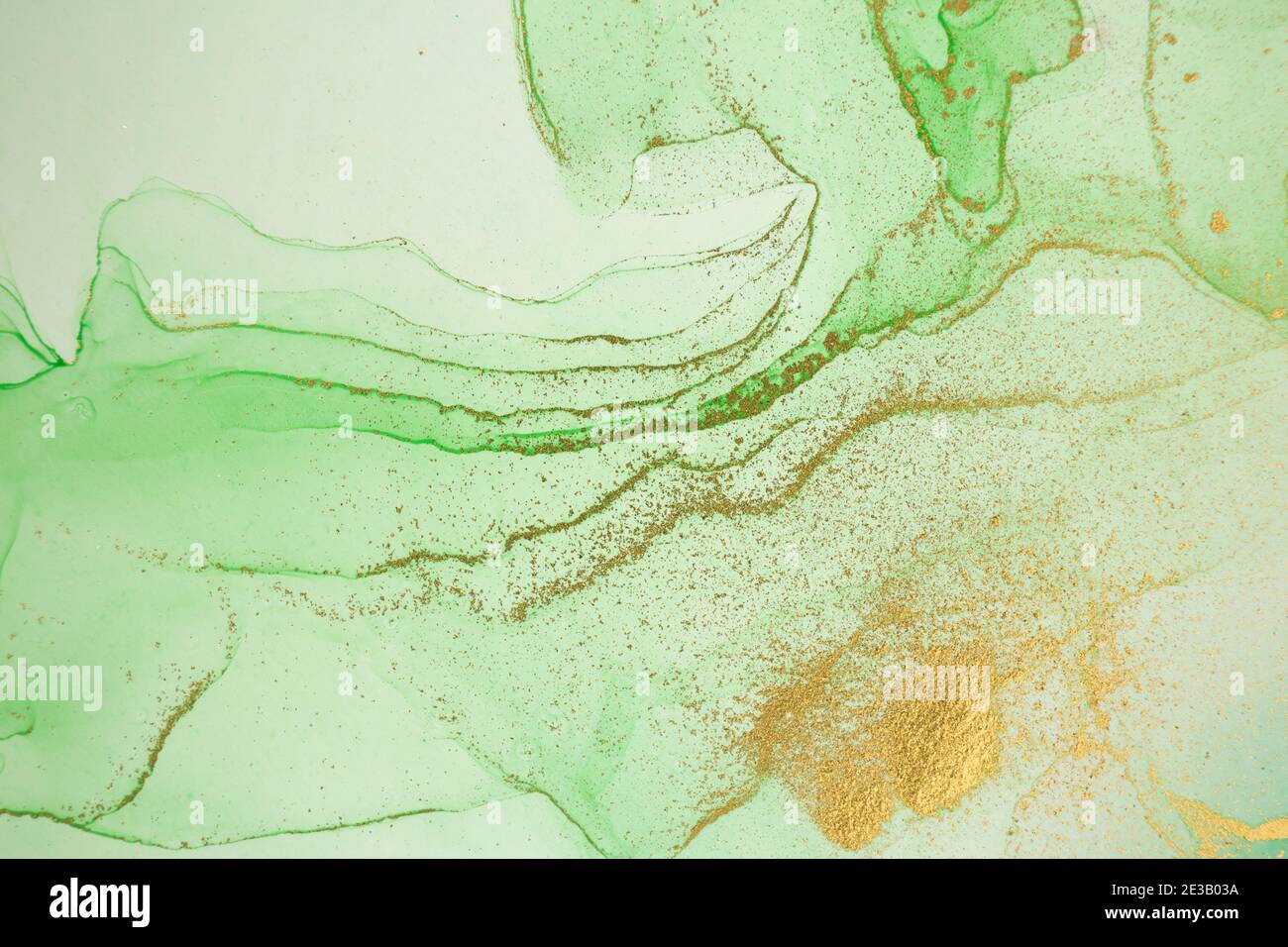 Light green watercolor background. Alcohol ink texture with gold layers ...