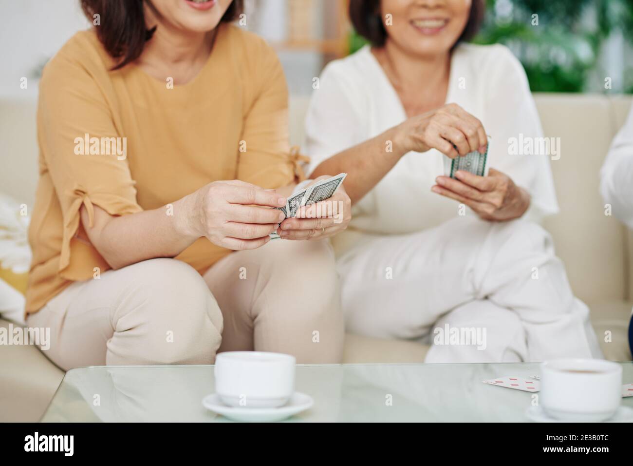 Female friends paying cards Stock Photo - Alamy