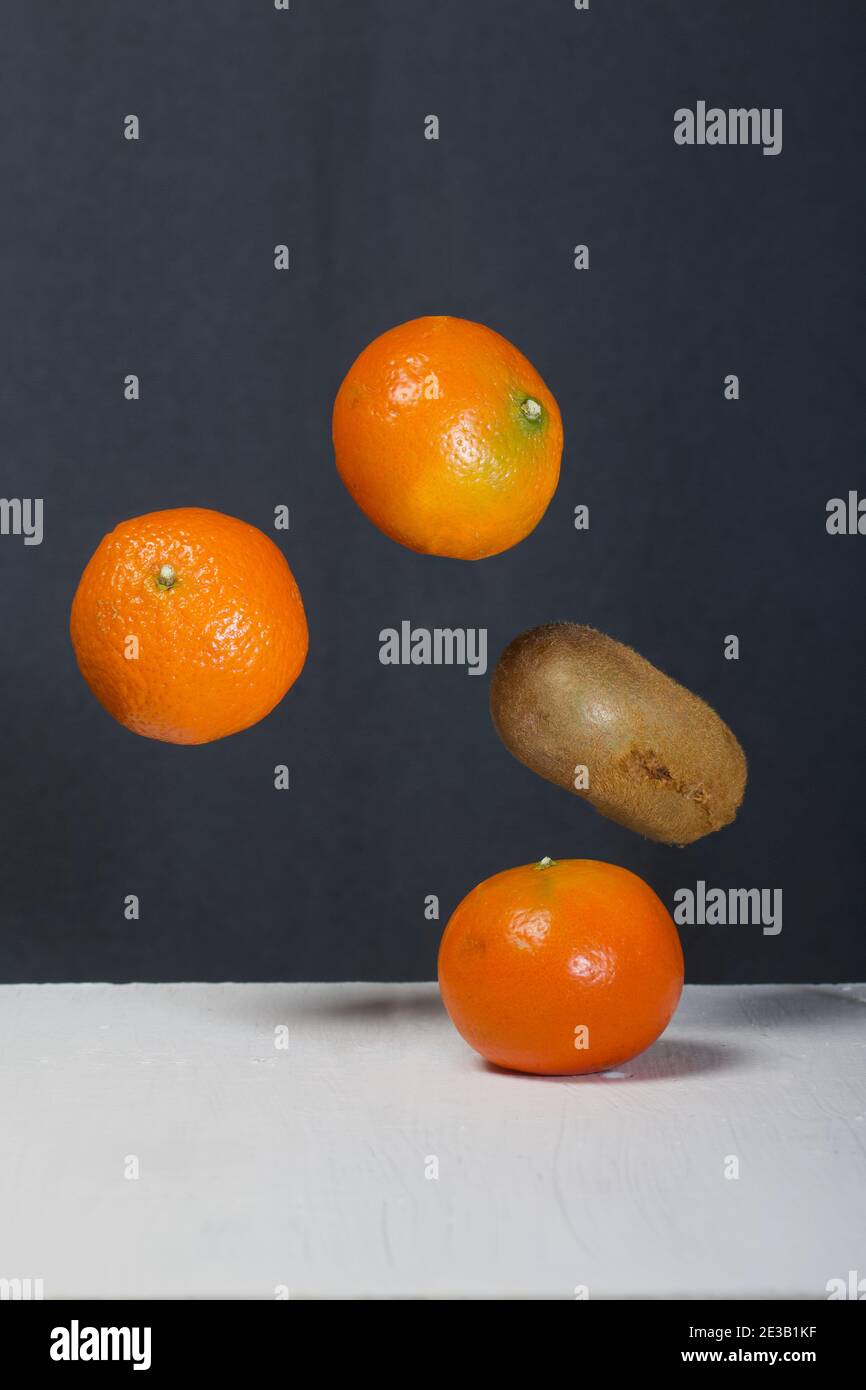 Tangerines and kiwis float above the table surface. Fruit levitation ...