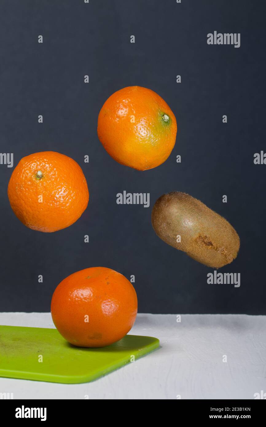 Tangerines and kiwis float above the table surface. Fruit levitation ...