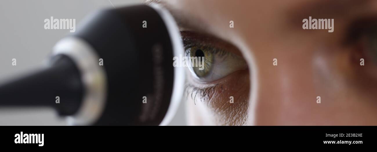 Eye of otorhinolaryngologist looking through otoscope in clinic Stock ...