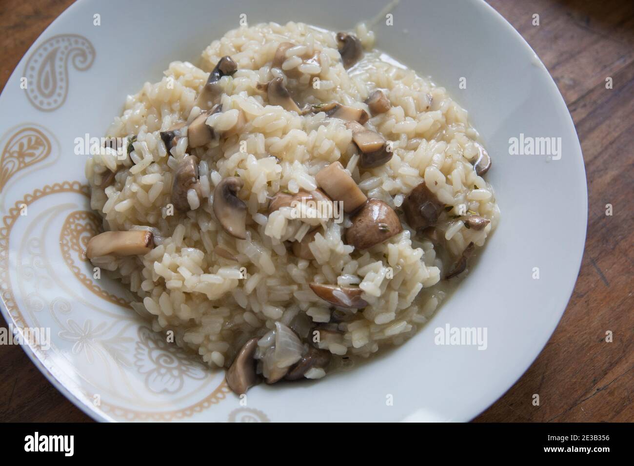 "Risotto ai funghi",cooked rice dish with slices of Common Mushrooms in a white bowl Stock Photo ...