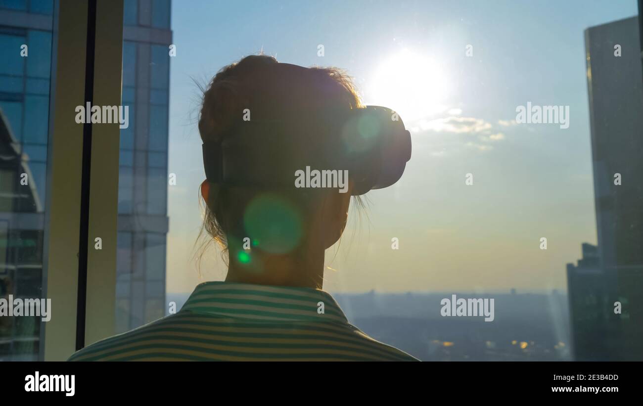 VR concept - young woman using virtual reality headset against ...