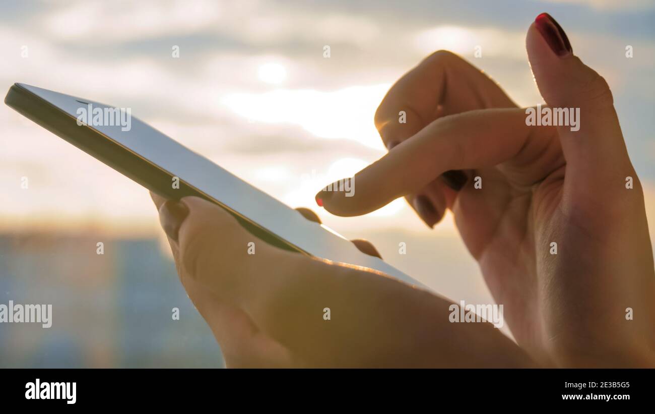 Closeup woman using smartphone sunset hi-res stock photography and ...