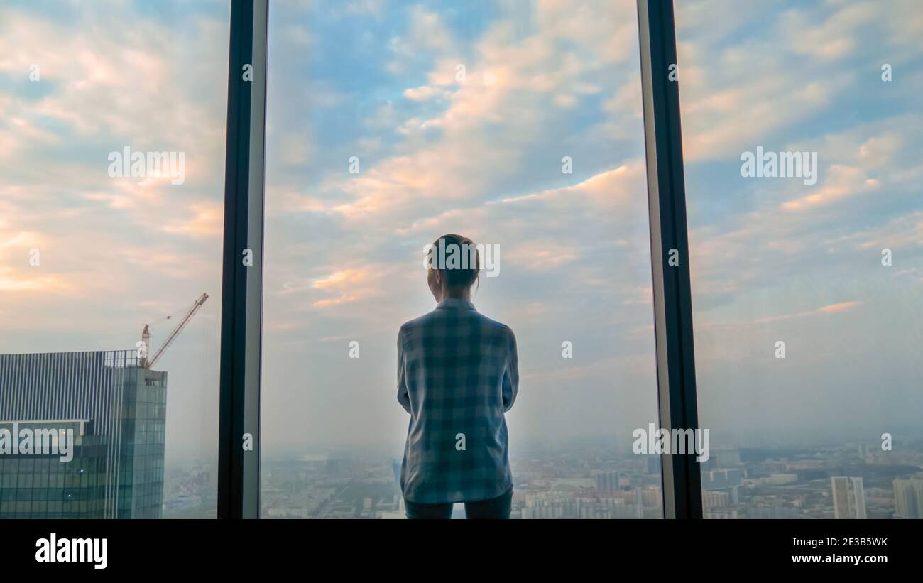 Woman looking through window building hi-res stock photography and ...